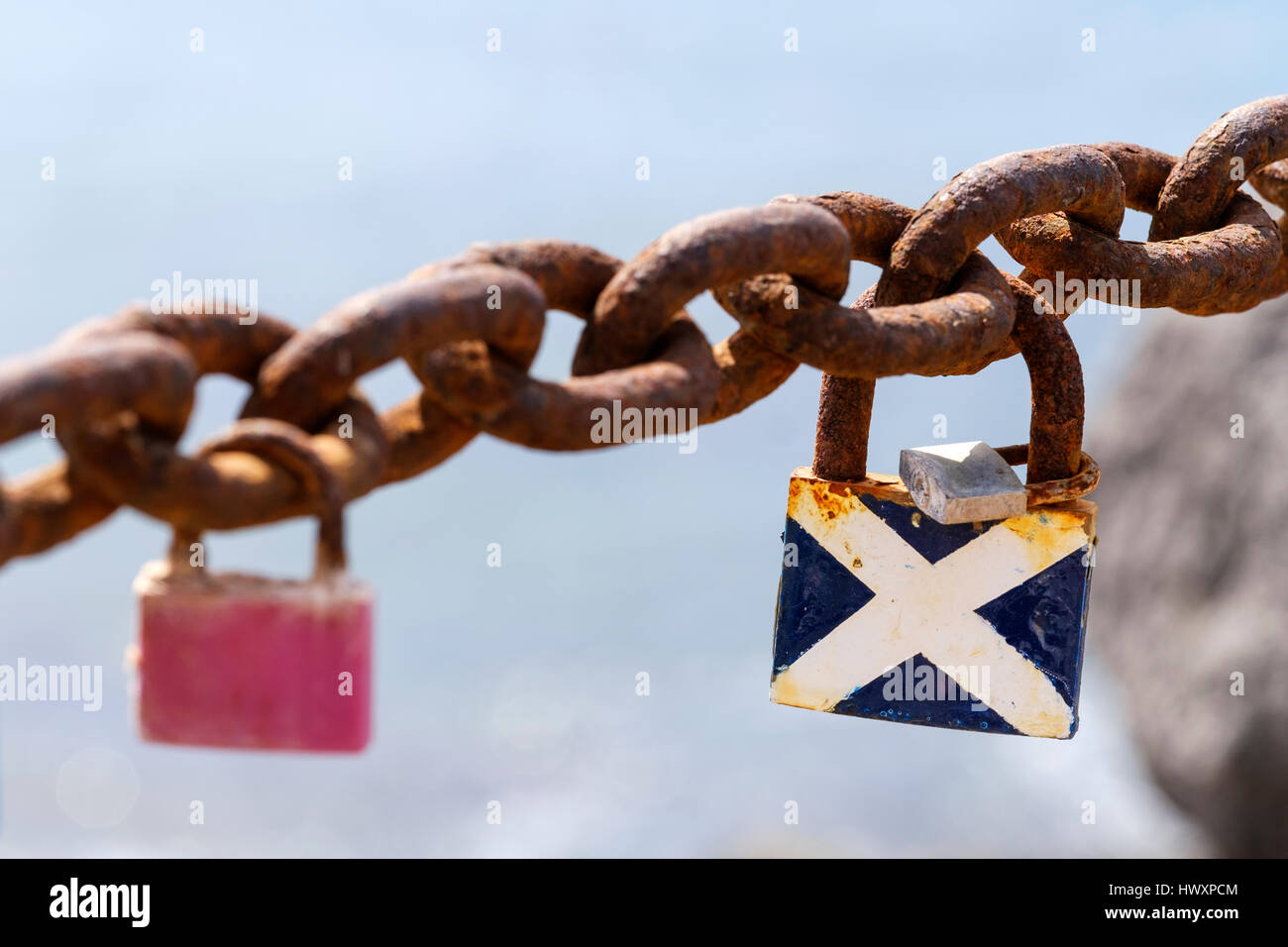 A padlock lovelock attached to an old barrier chain and painted in the ...
