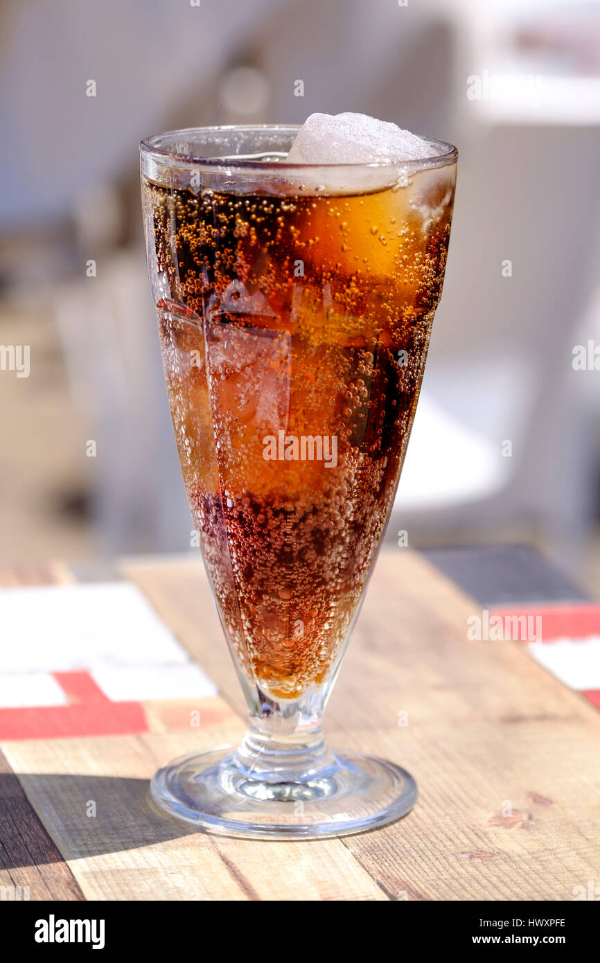 A refreshing glass of Coca Cola o a table waiting to be drunk a warm ...