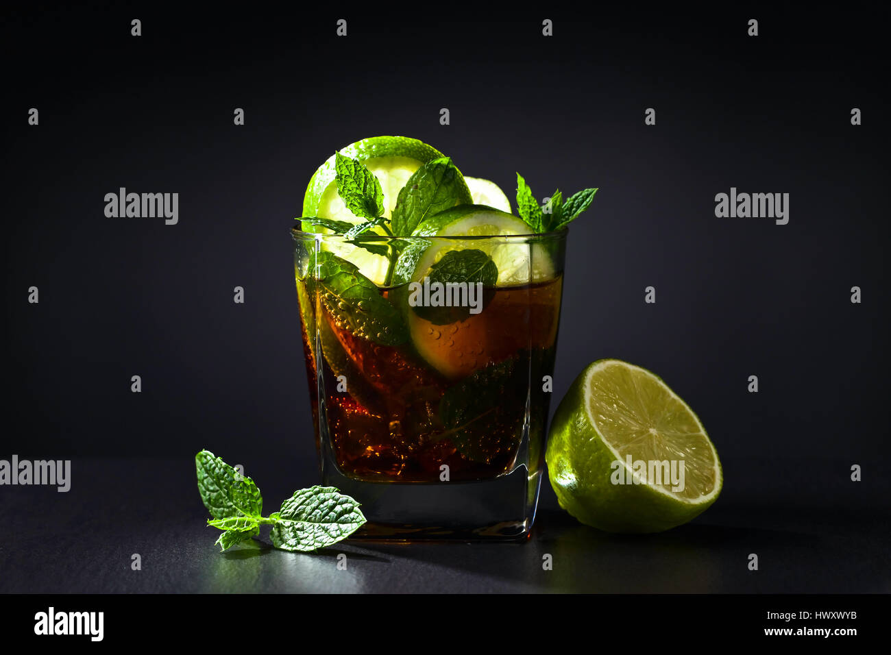 Cola with lime , ice and peppermint on black table Stock Photo - Alamy