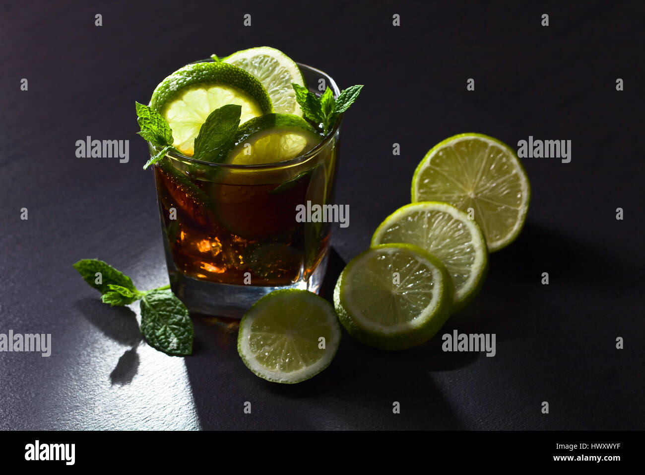 Cola with lime , ice and peppermint on black table Stock Photo - Alamy