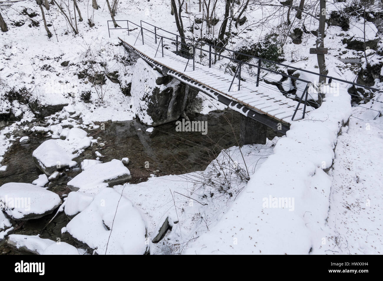 Mountain trail path and bridge in a snowy landscape Stock Photo - Alamy