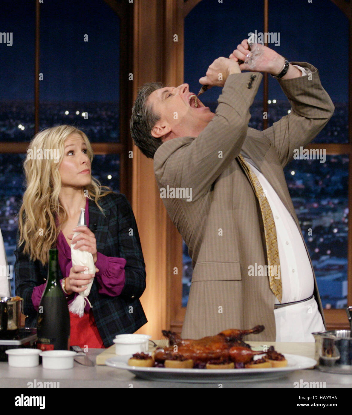 Actress Kristen Bell, left, watches host Craig Ferguson eat icing out ...