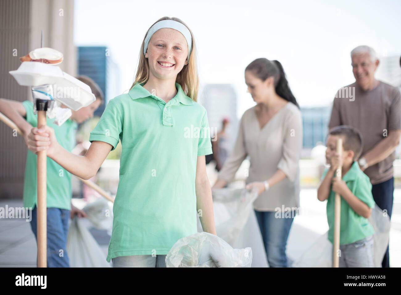 Group of volunteering children collecting garbage with litter sticks ...
