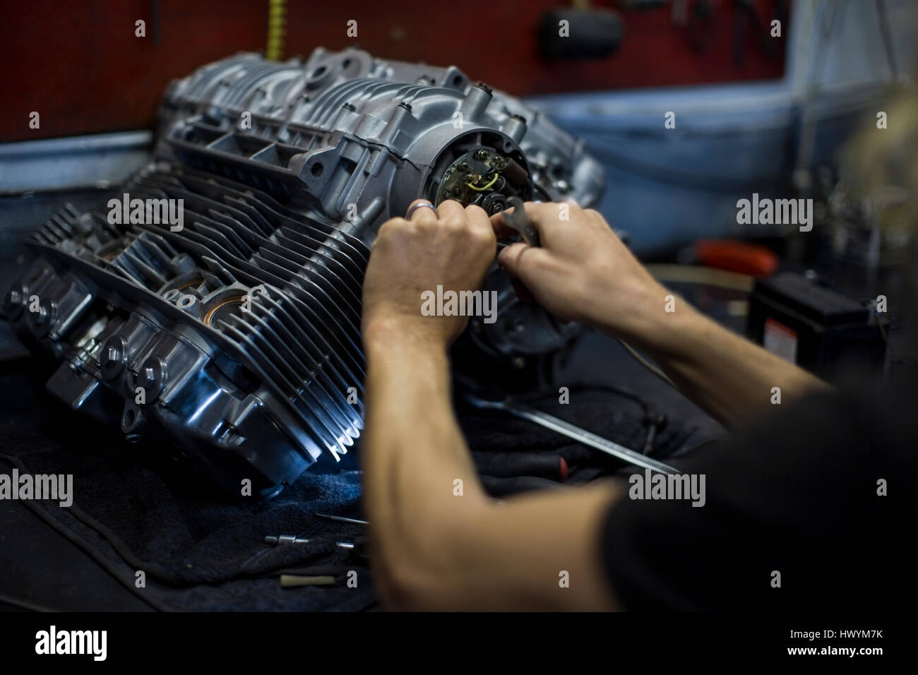 Mechanic working on motorcycle engine in workshop Stock Photo - Alamy