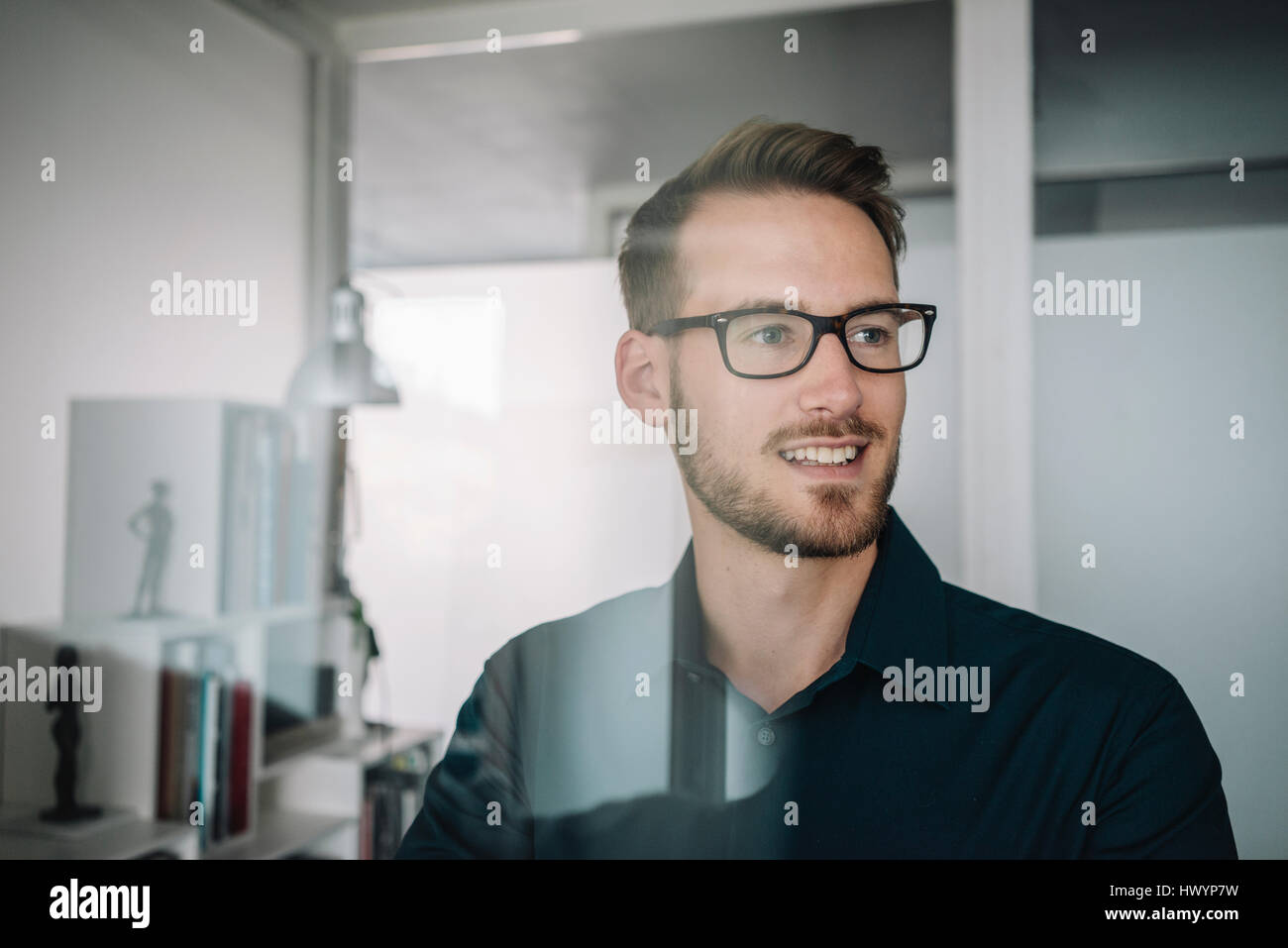 Smiling businessman behind glass pane Stock Photo - Alamy