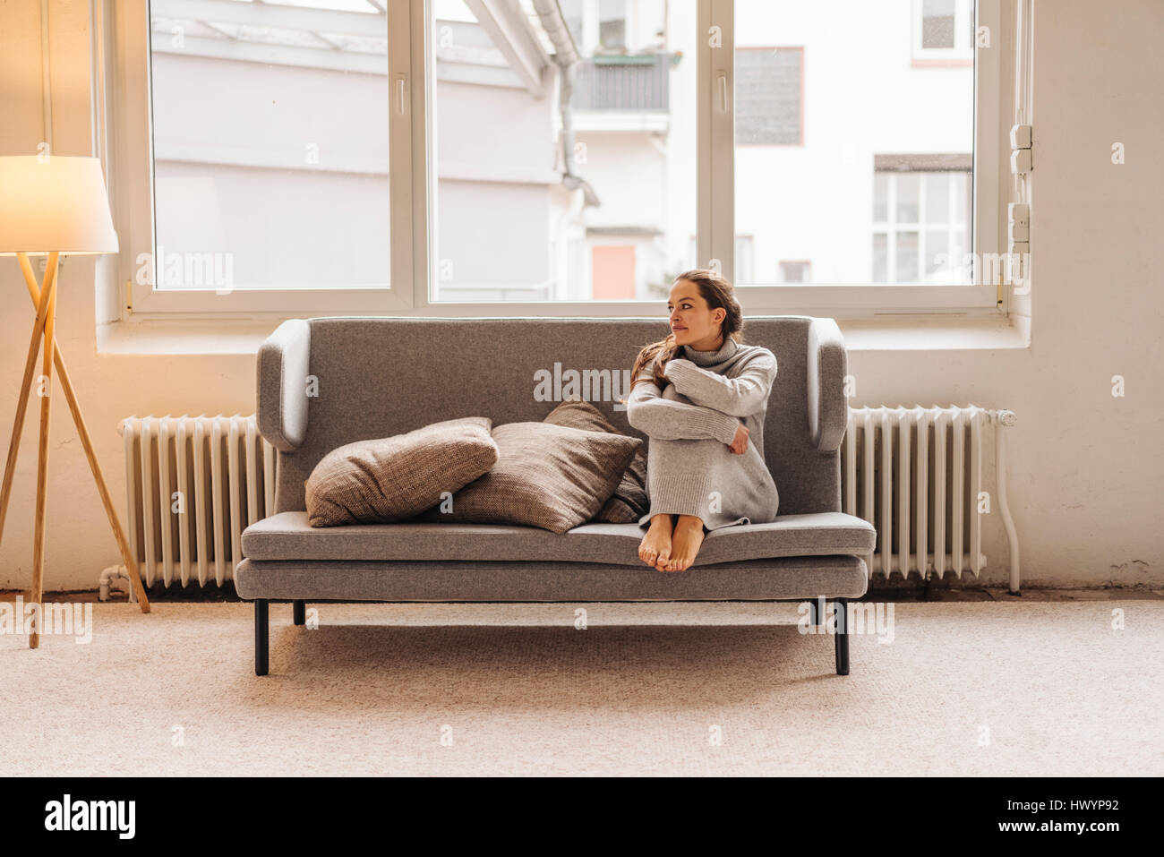 Woman sitting sideways on couch hi-res stock photography and images - Alamy