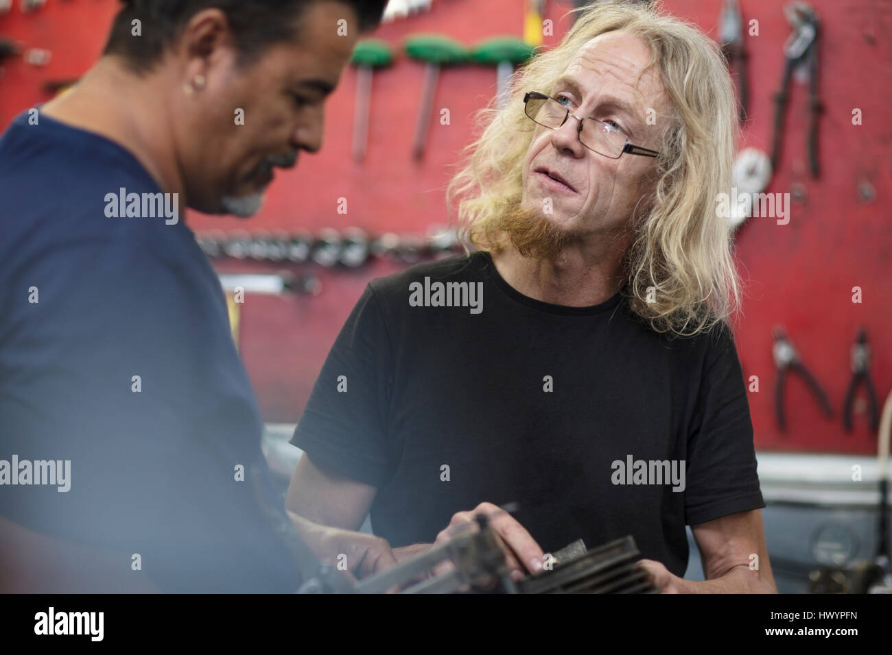 Two mechanics discussing in workshop Stock Photo - Alamy