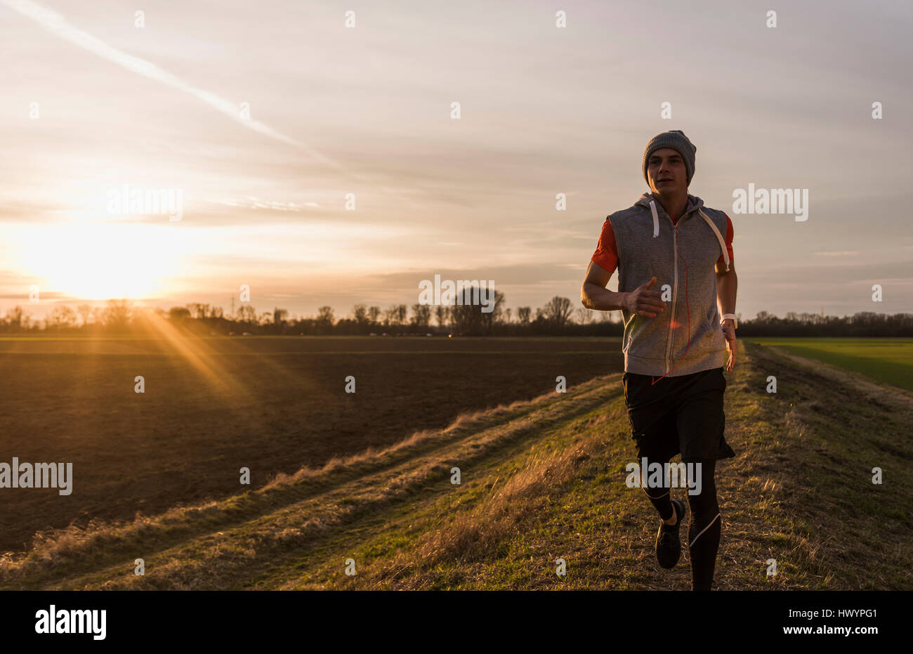 Man running in rural landscape at sunset Stock Photo - Alamy