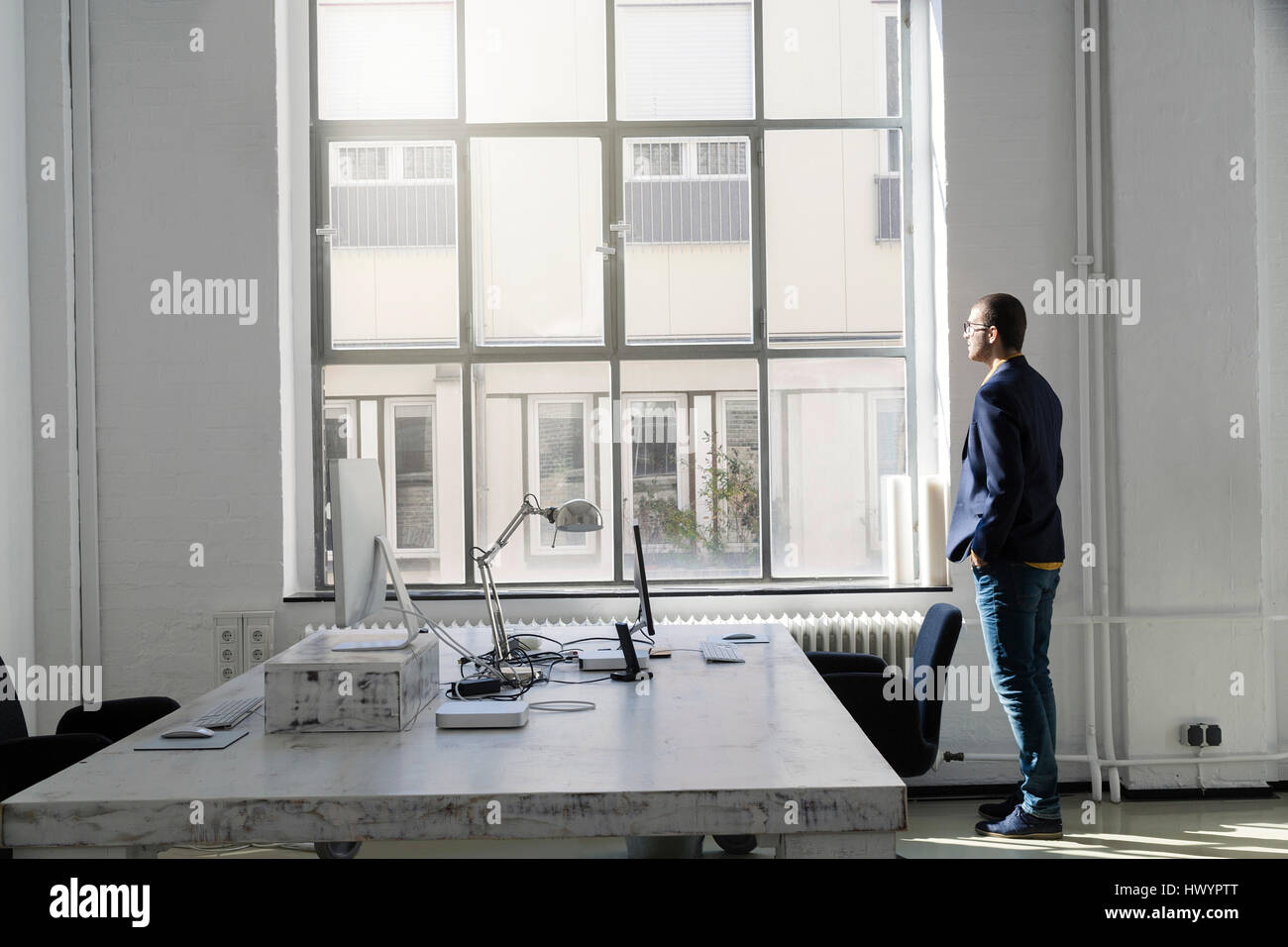 Young businessman looking out of office window Stock Photo - Alamy