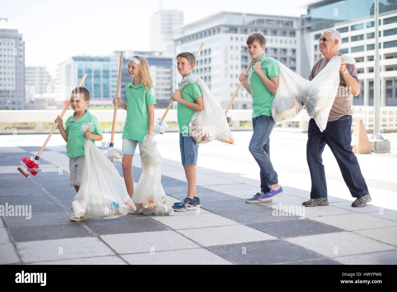 Group of volunteering children collecting garbage with litter sticks ...