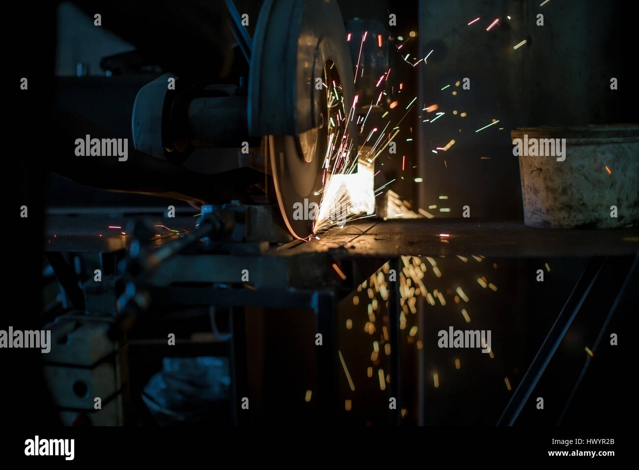 Mechanic using bench grinder in workshop Stock Photo - Alamy