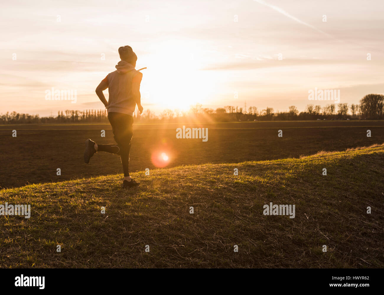 Man running in rural landscape at sunset Stock Photo - Alamy