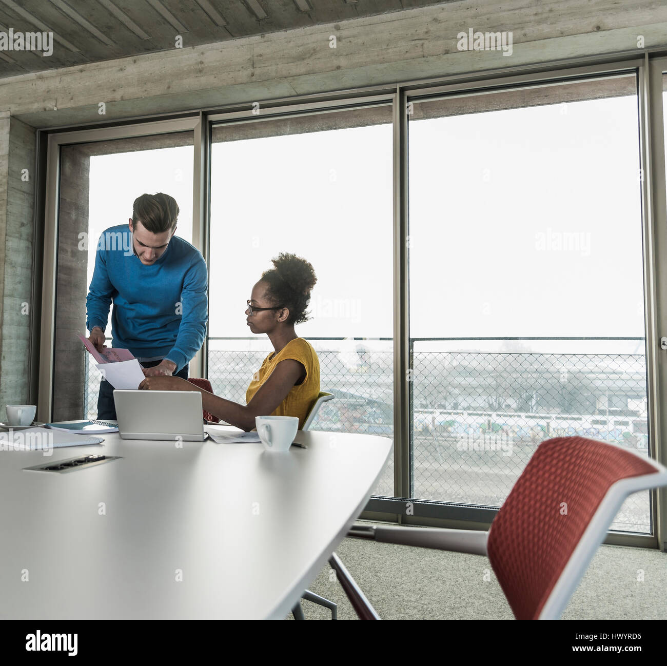 Two colleagues discussing in office Stock Photo - Alamy