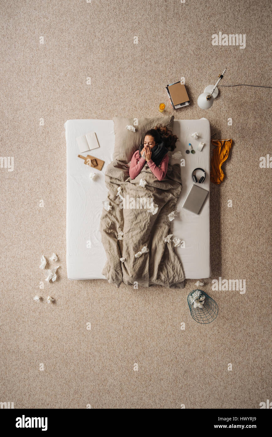 Sick woman lying in bed, top view Stock Photo - Alamy