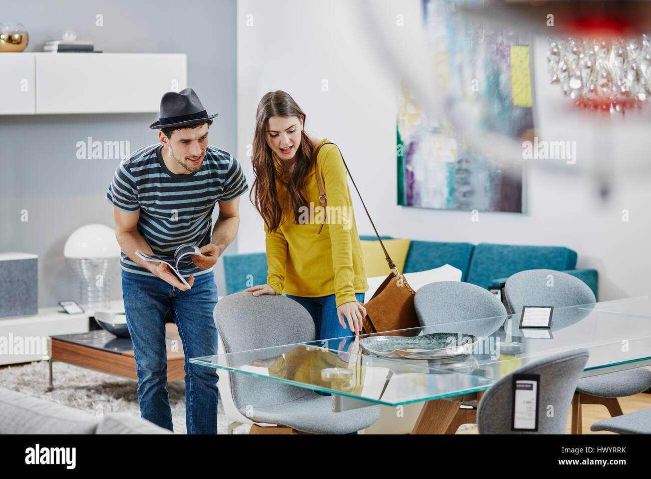 Couple in furniture store looking at dining table Stock Photo - Alamy