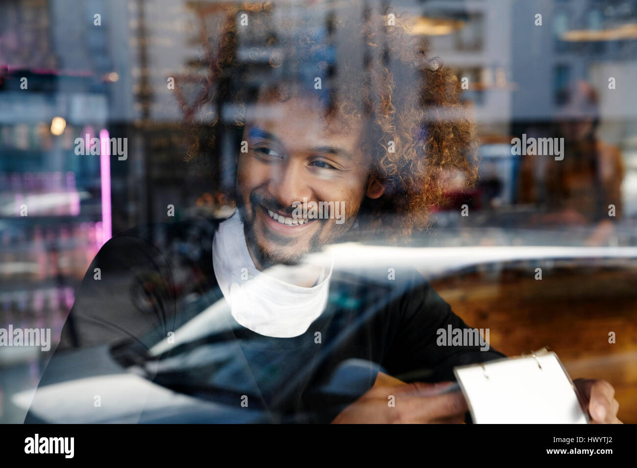 Portrait of smiling young man behind windowpane Stock Photo - Alamy
