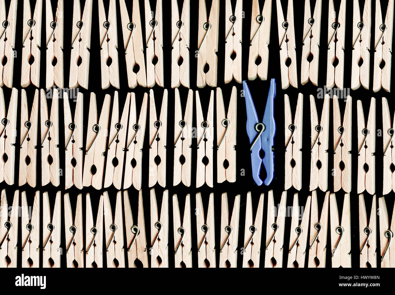Blue clothes peg between wooden clothes pegs Stock Photo - Alamy