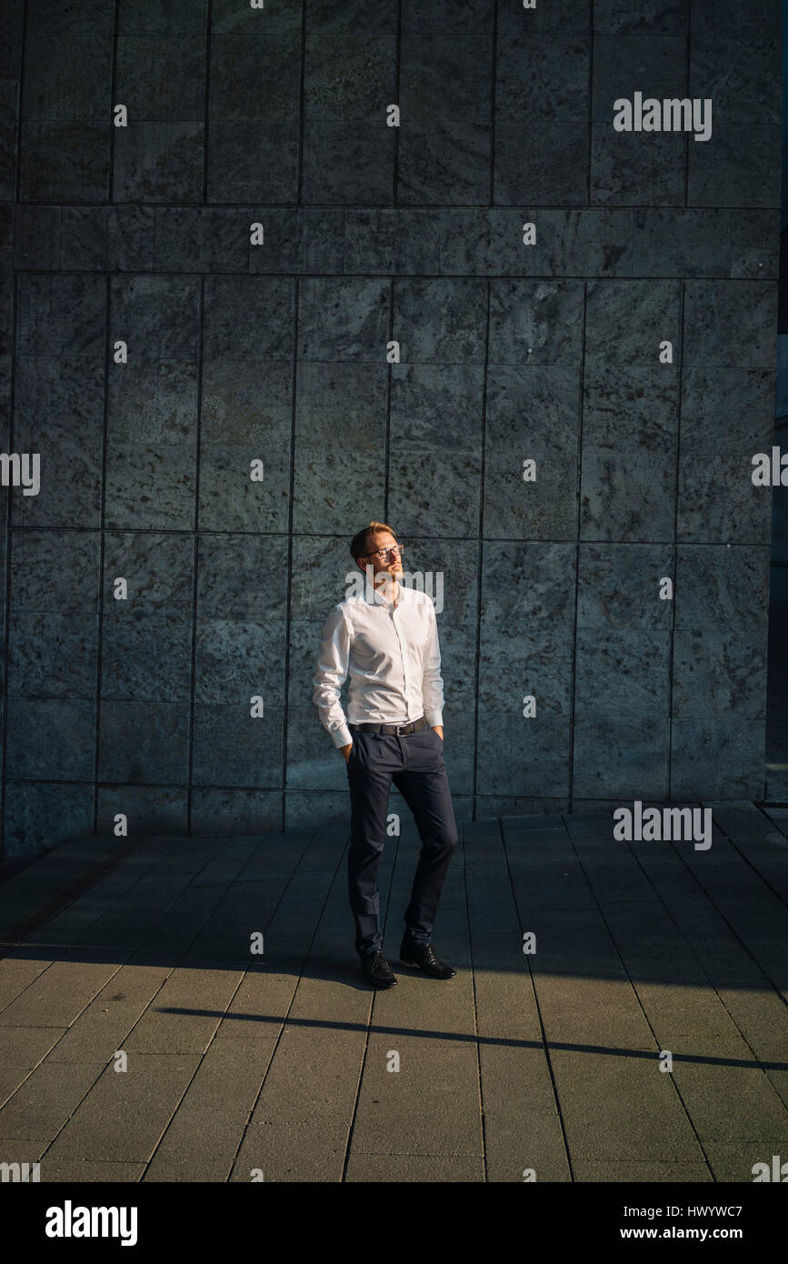 Businessman standing outside building Stock Photo - Alamy
