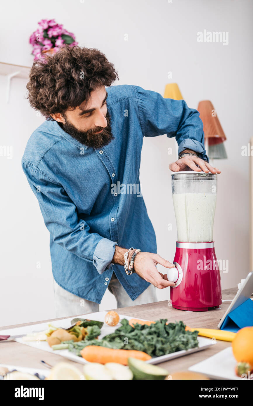 Man preparing smoothie with fresh fruits and vegetables at home Stock ...