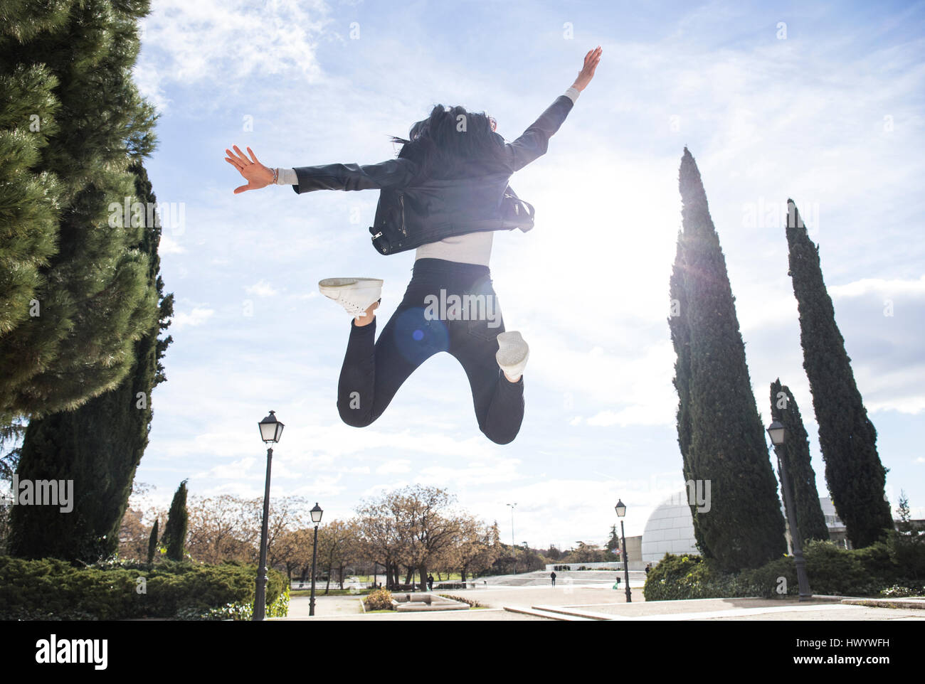Back view of young woman jumping in the air at backlight Stock Photo ...