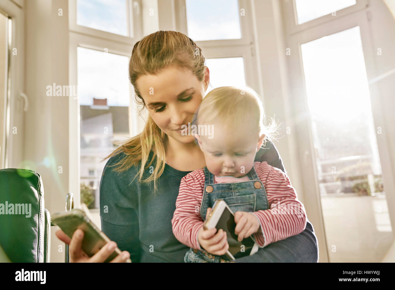 Mother and baby girl holding cell phones Stock Photo - Alamy