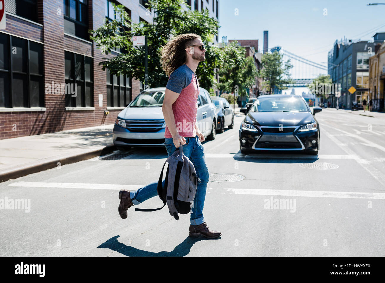 USA, New York City, man crossing the street in Williamsburg, Brooklyn ...