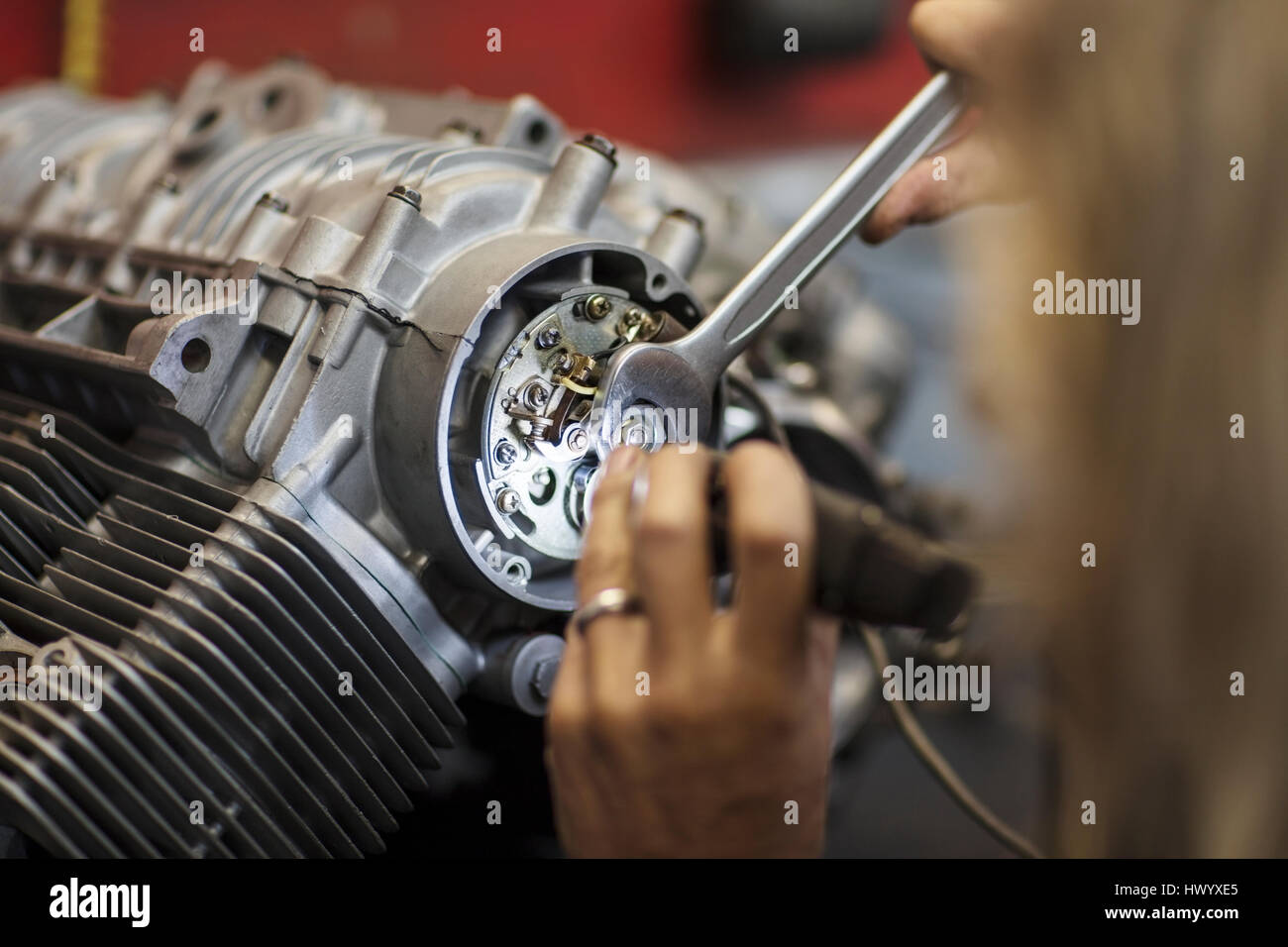 Mechanic working on motorcycle engine in workshop Stock Photo - Alamy