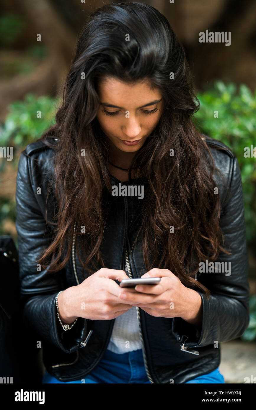 Young woman using a cell phone outdoors Stock Photo - Alamy