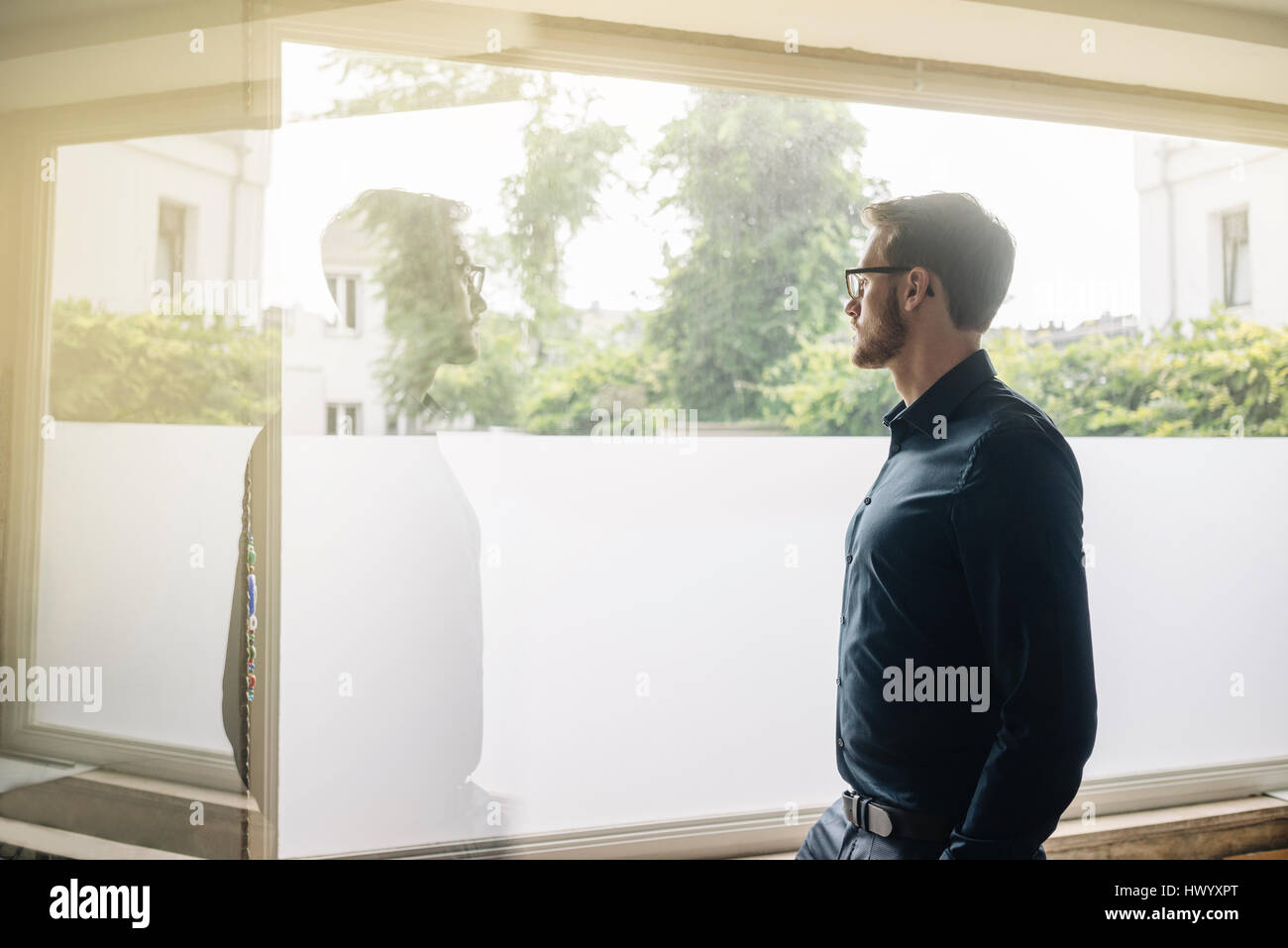 Pensive businessman looking out of window Stock Photo - Alamy