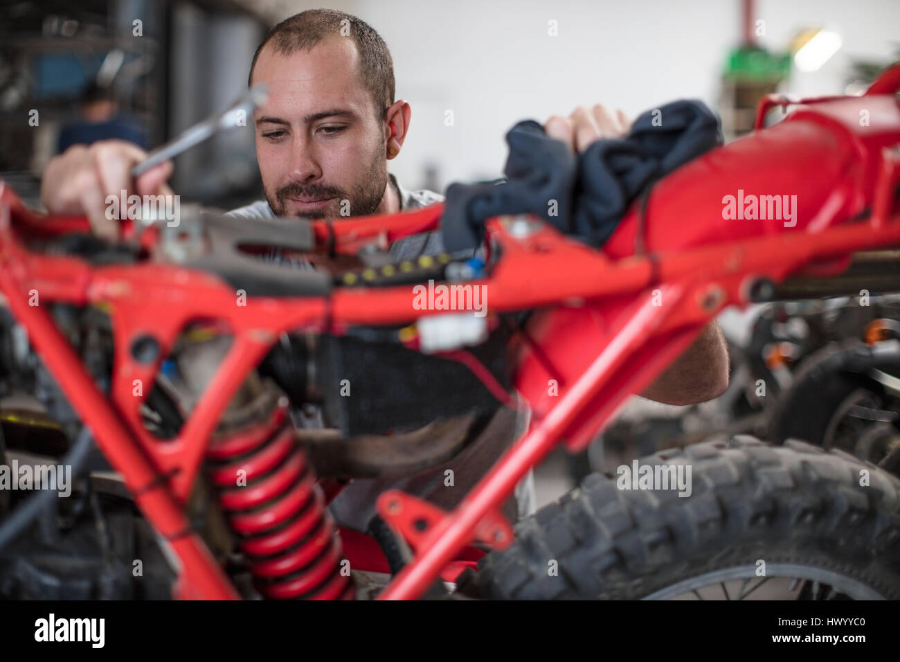 Mechanic working on motorcycle in workshop Stock Photo - Alamy