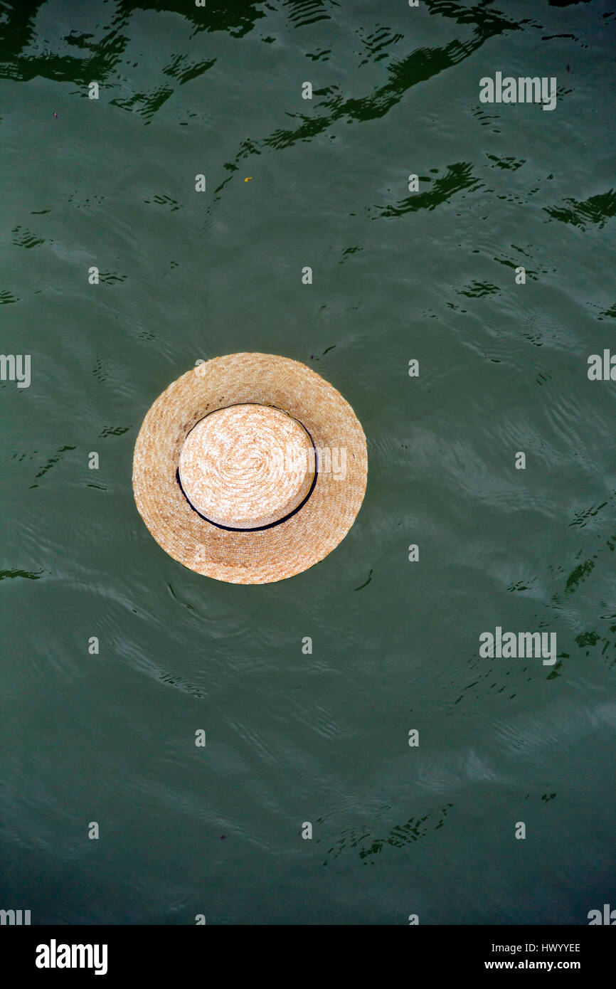 Straw hat floating on water Stock Photo - Alamy