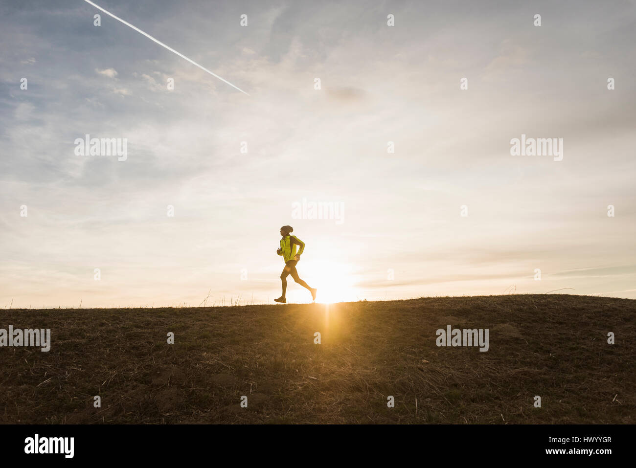 Man running in rural landscape at sunset Stock Photo - Alamy