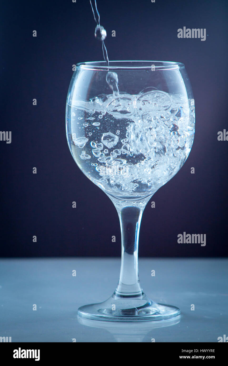 Clean drinking water from a source pouring into a clear glass beaker in ...