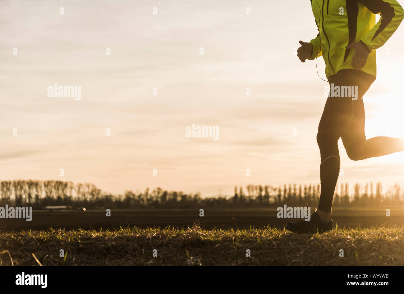Man running in rural landscape at sunset Stock Photo - Alamy