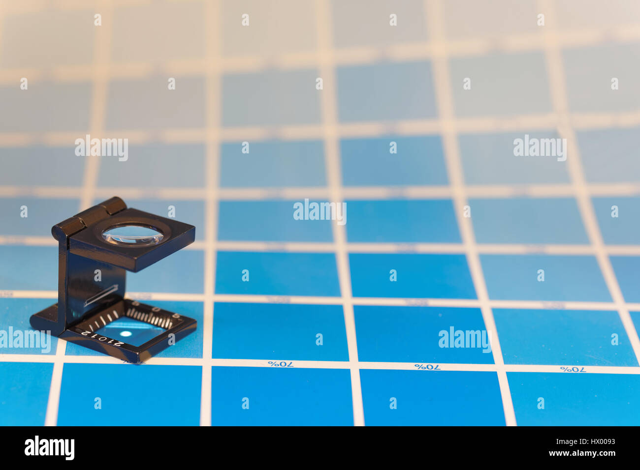 Magnifier or printer's loupe sits on a cyan test sheet in a pre-press ...