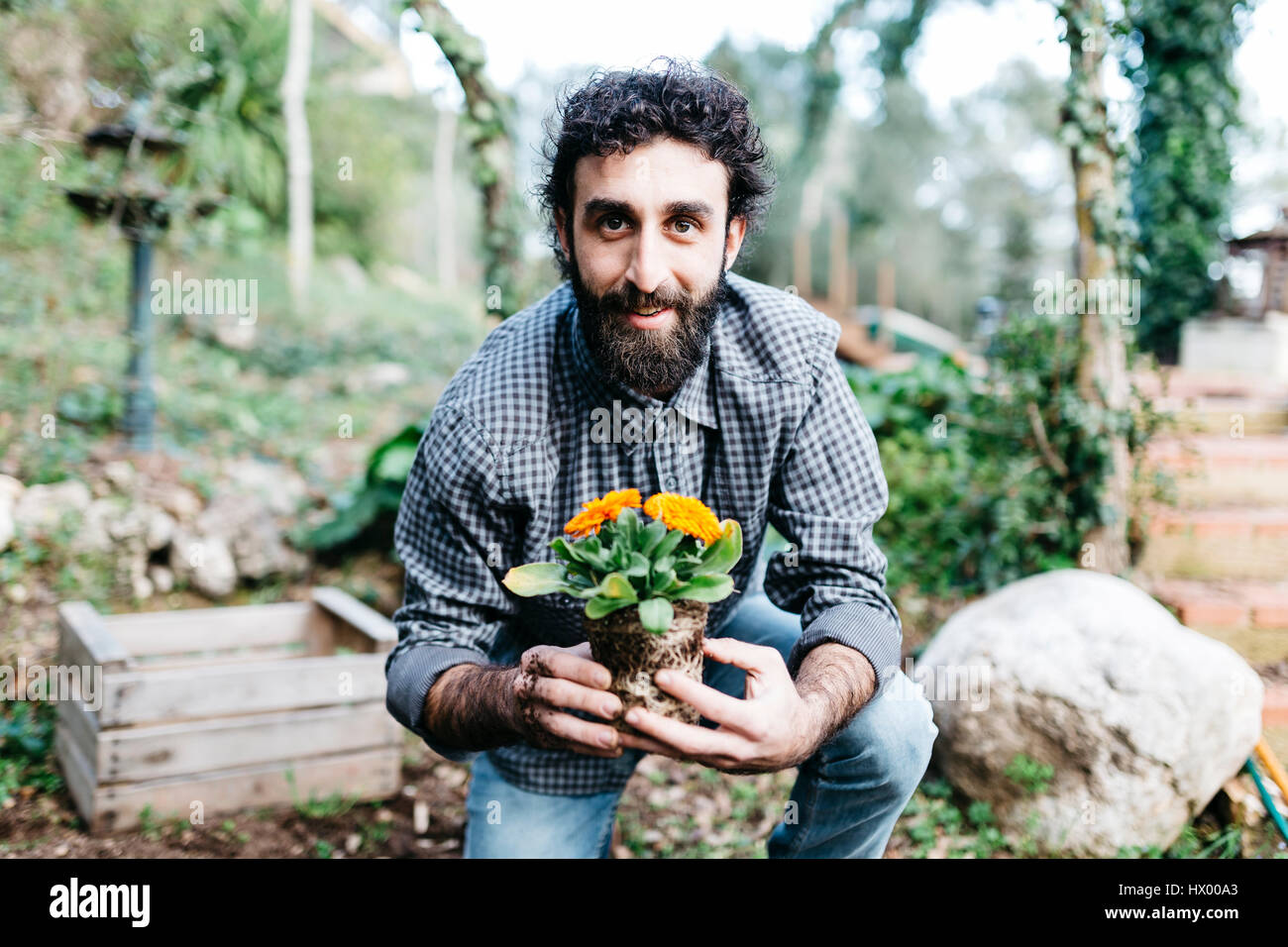 Smiling gardener holding a flower Stock Photo - Alamy