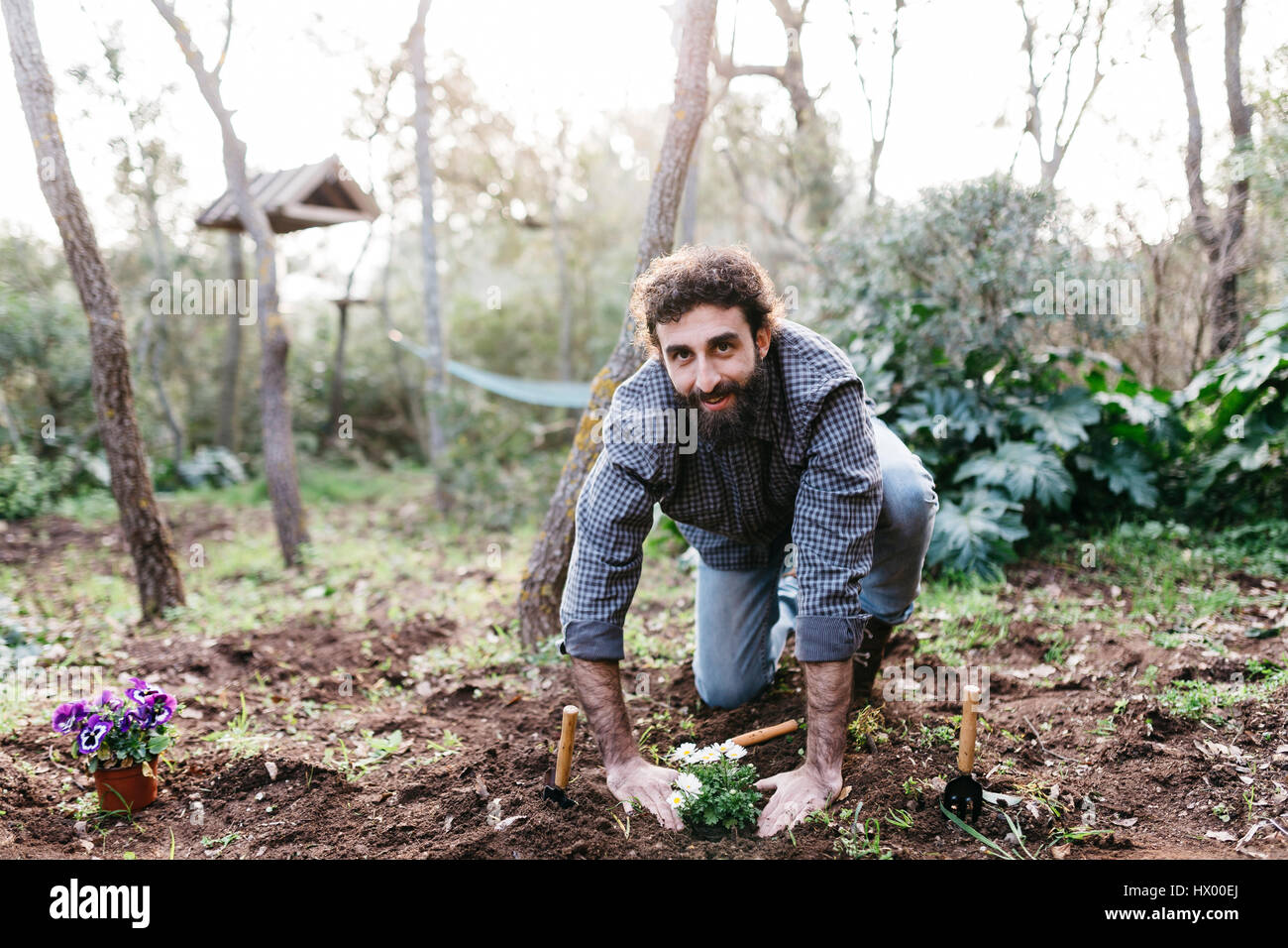 Man planting flowers in his garden Stock Photo - Alamy