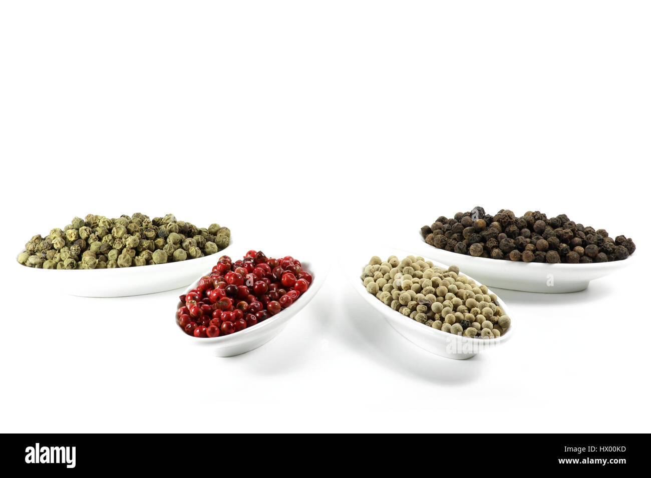 different colored peppercorns sorted in small ceramic bowls isolated on ...