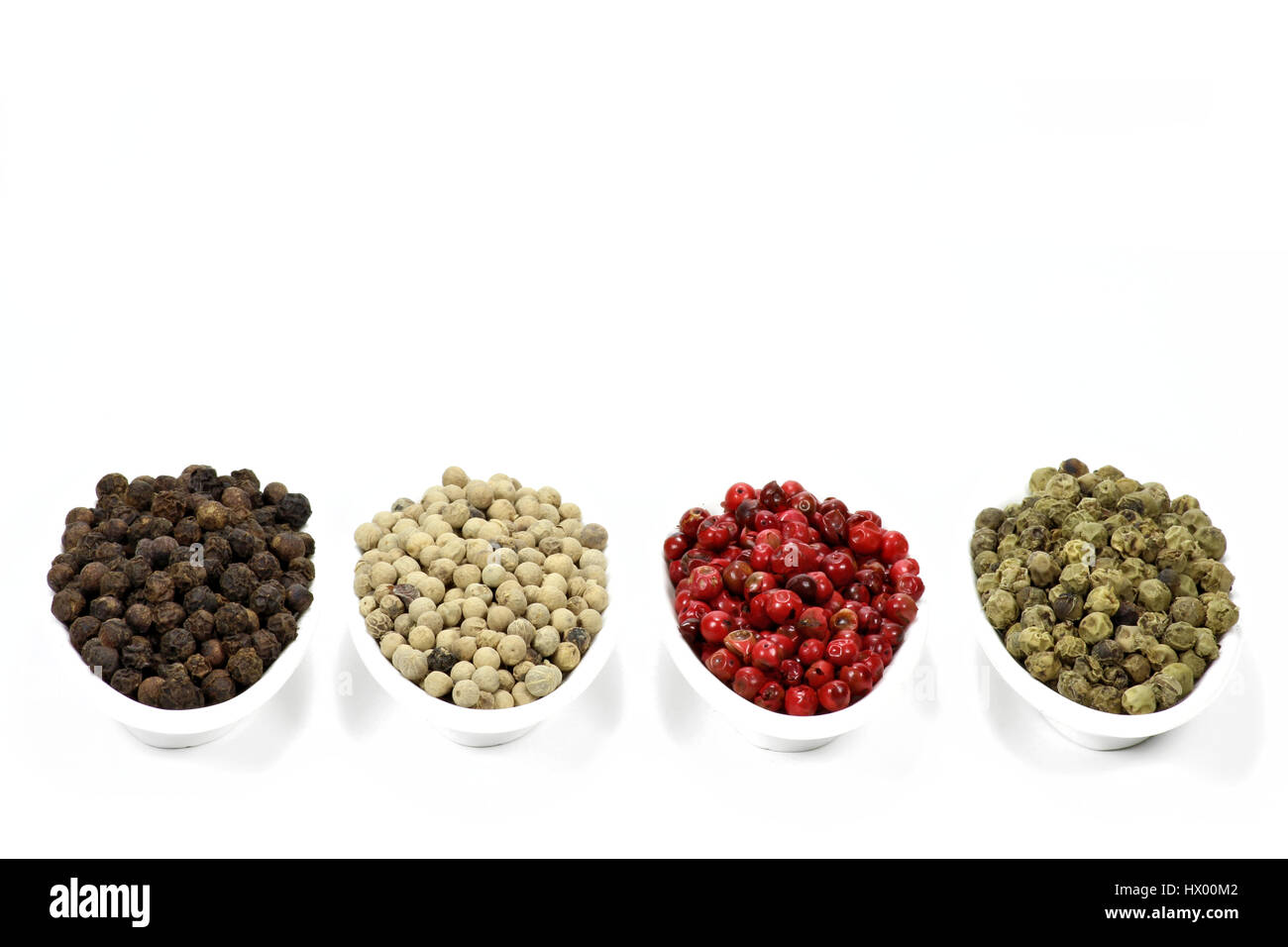 different colored peppercorns sorted in small ceramic bowls isolated on ...