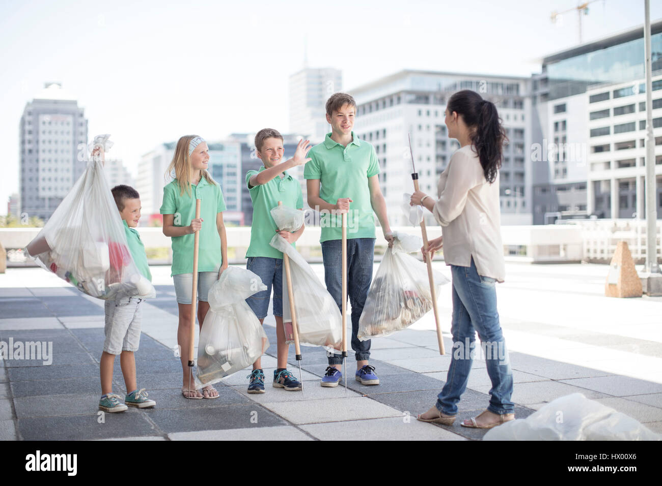 Group of volunteering children collecting garbage with litter sticks ...