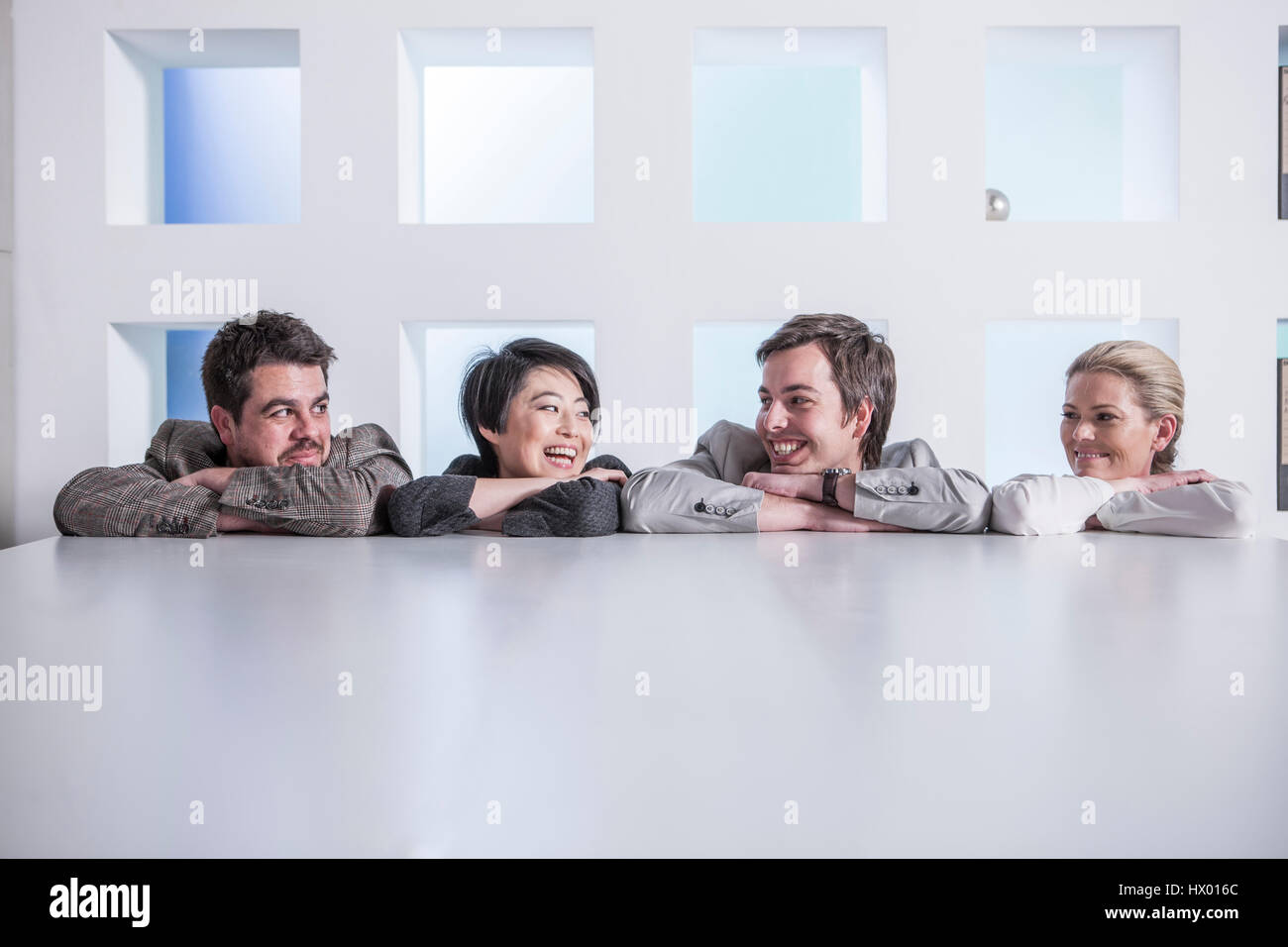 Four smiling colleagues in office Stock Photo - Alamy