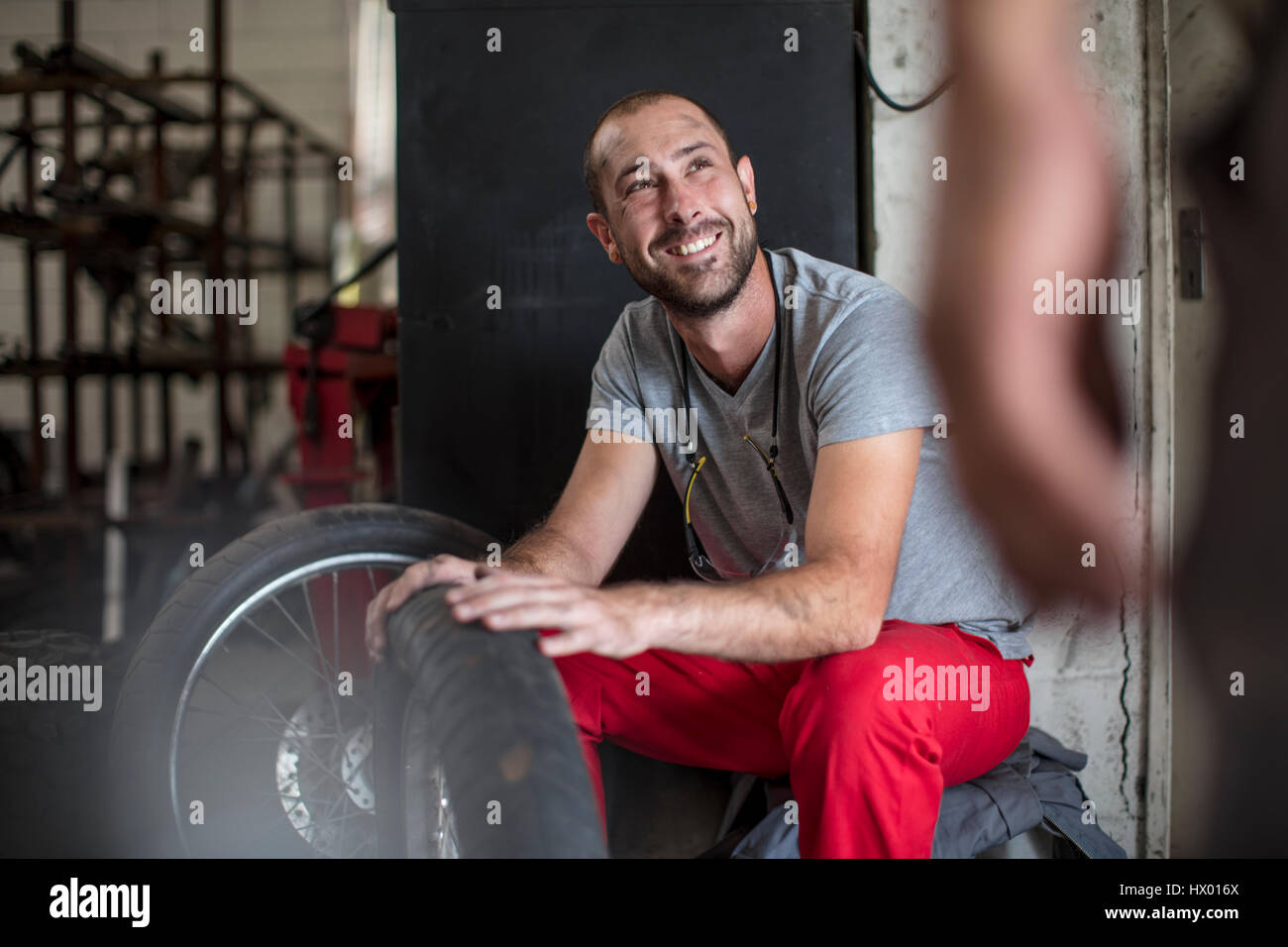 Smiling mechanic in workshop looking at colleague Stock Photo - Alamy