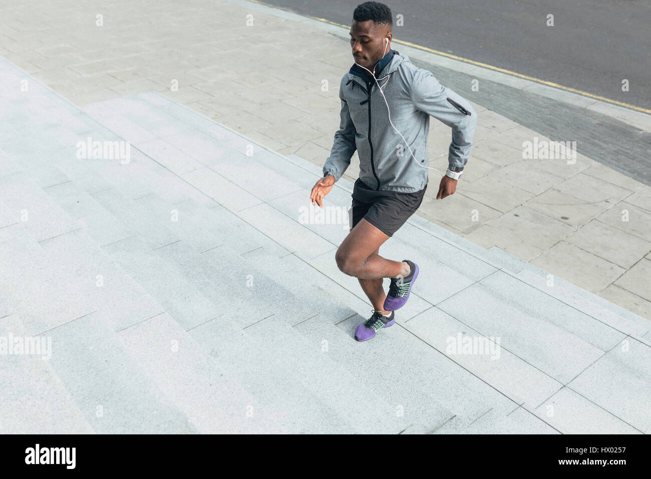 Young man running up stairs Stock Photo - Alamy