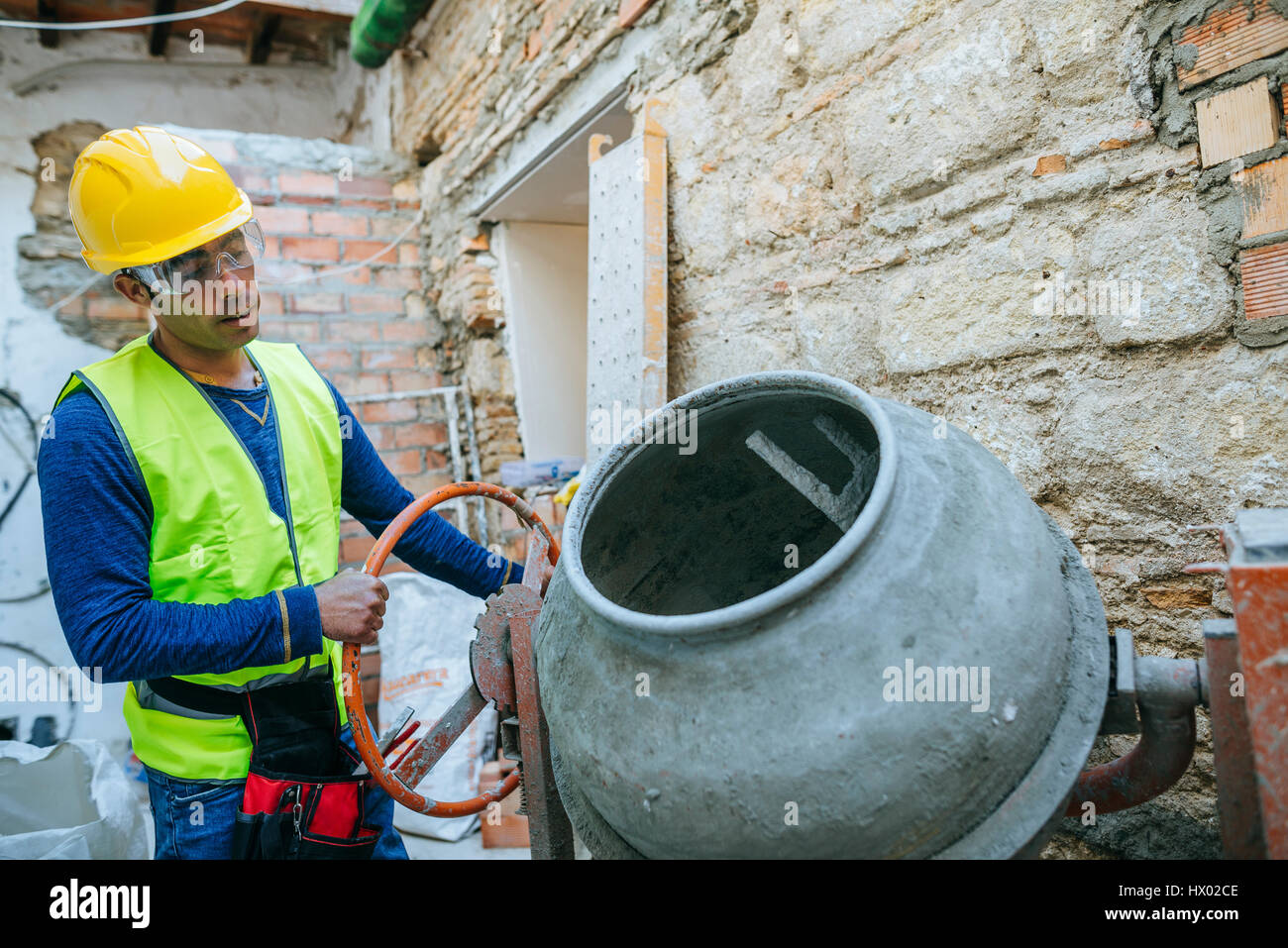 Construction worker working with a concrete mixer Stock Photo - Alamy