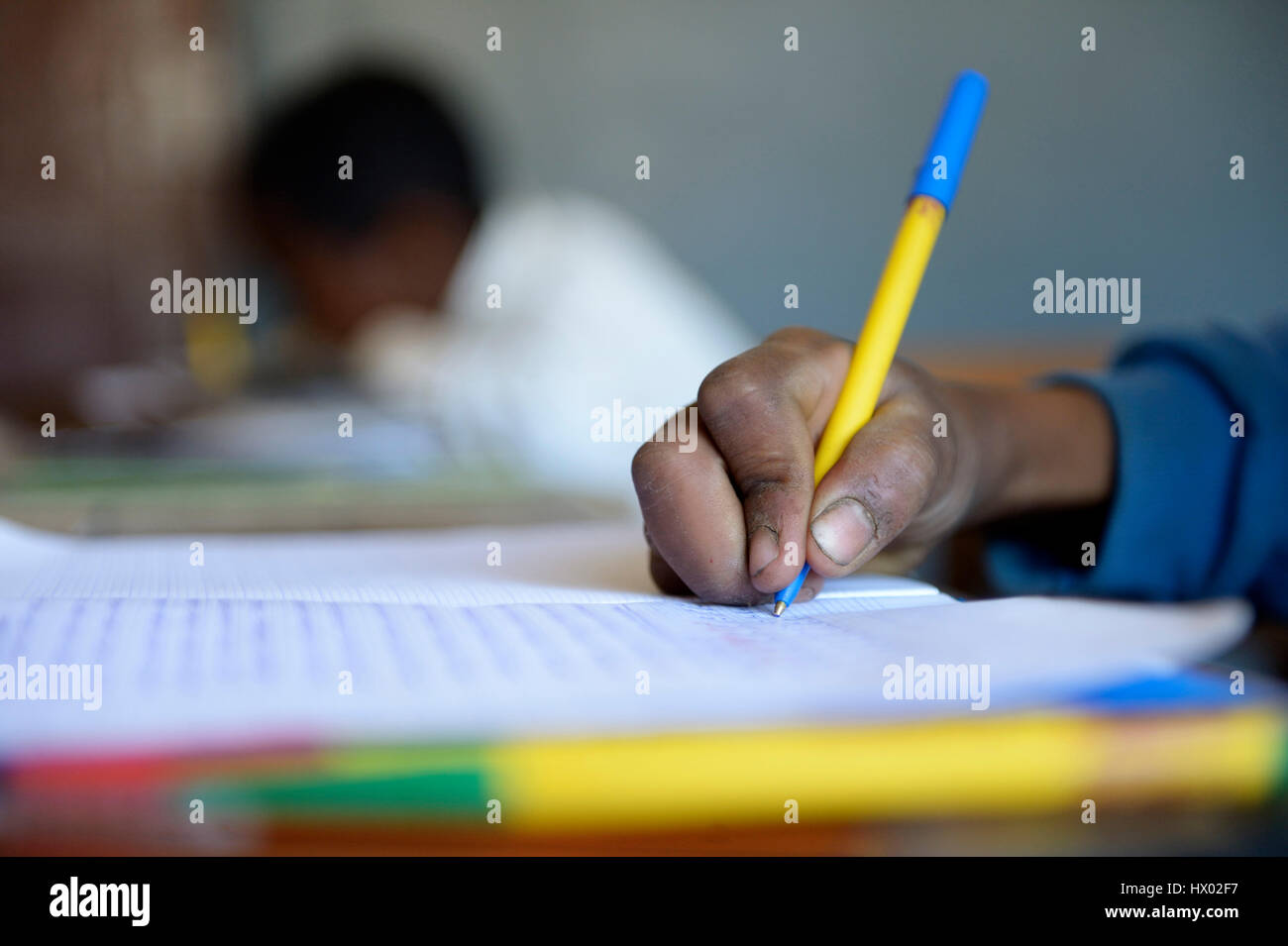 Madagascar, Fianarantsoa, Schoolboy writing in notebook Stock Photo - Alamy