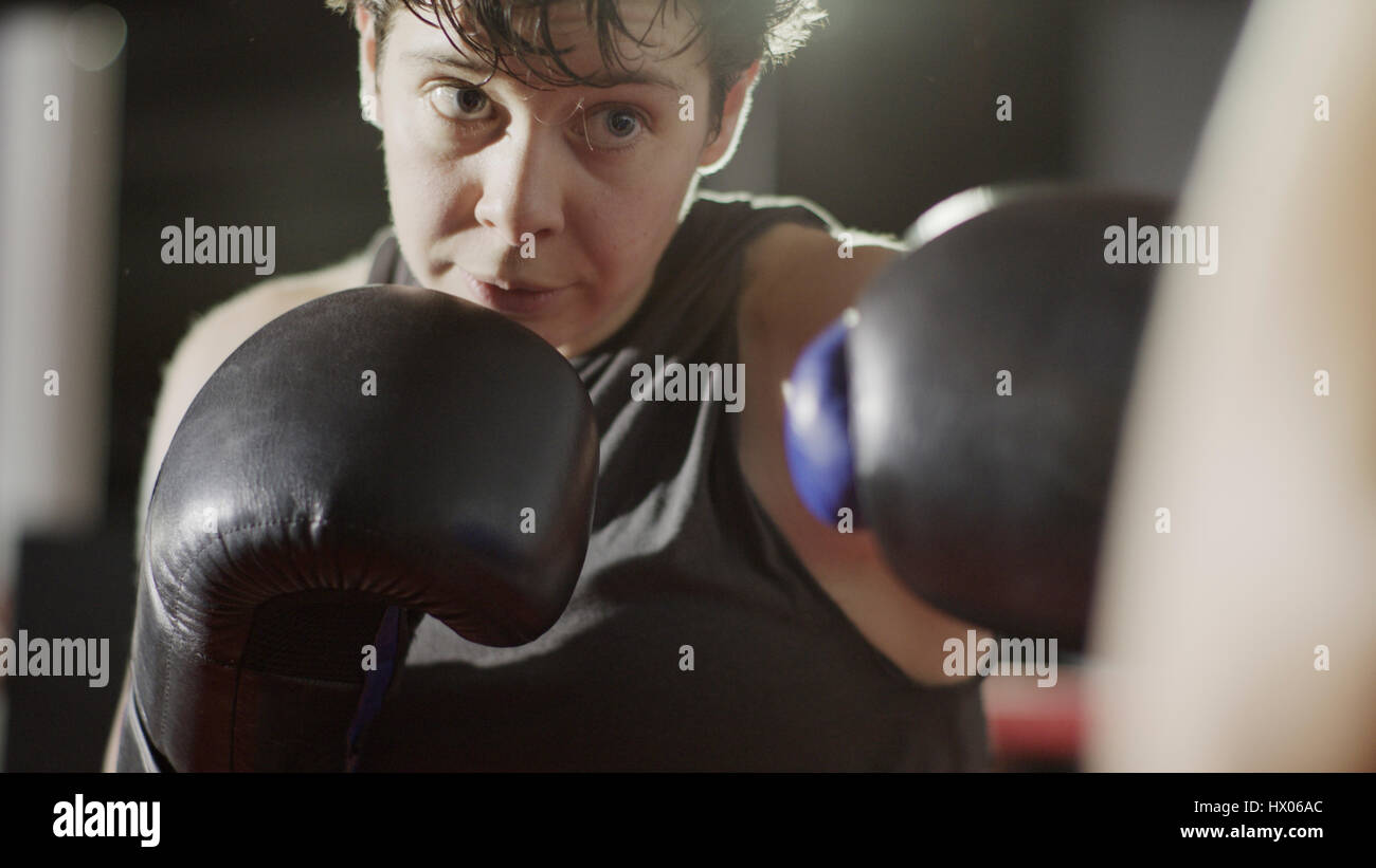 Close up of female boxer in boxing gloves standing in boxing ring ...