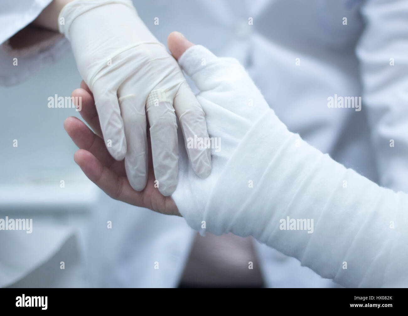 Doctor applying a plaster cast and bandages to patient forearm and ...