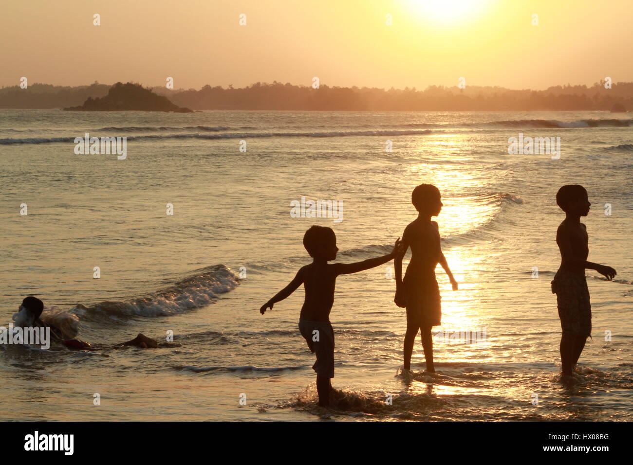 Sri Lankan boys playing in the surf at sunset on the Southern Coast of ...
