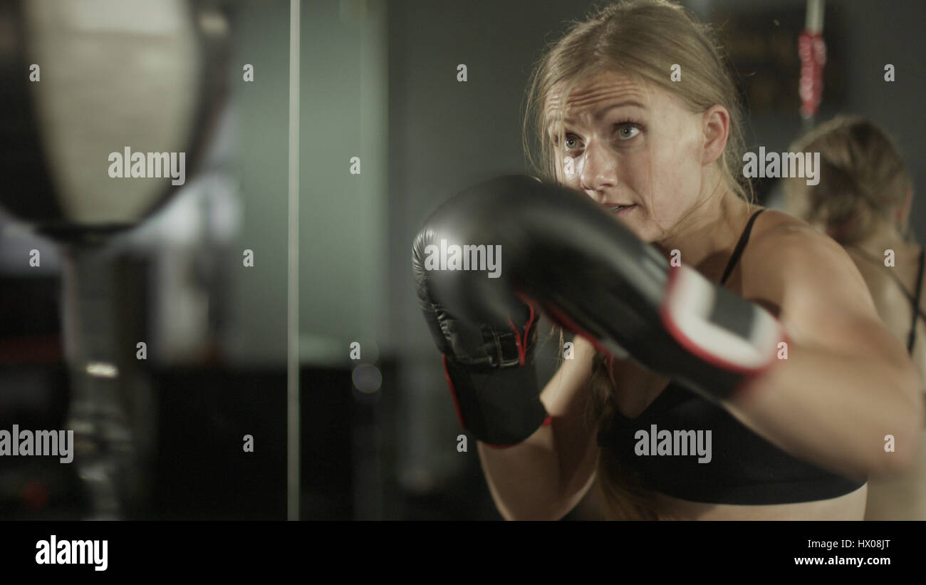 Blurred view of female boxer working out and training with punching ...