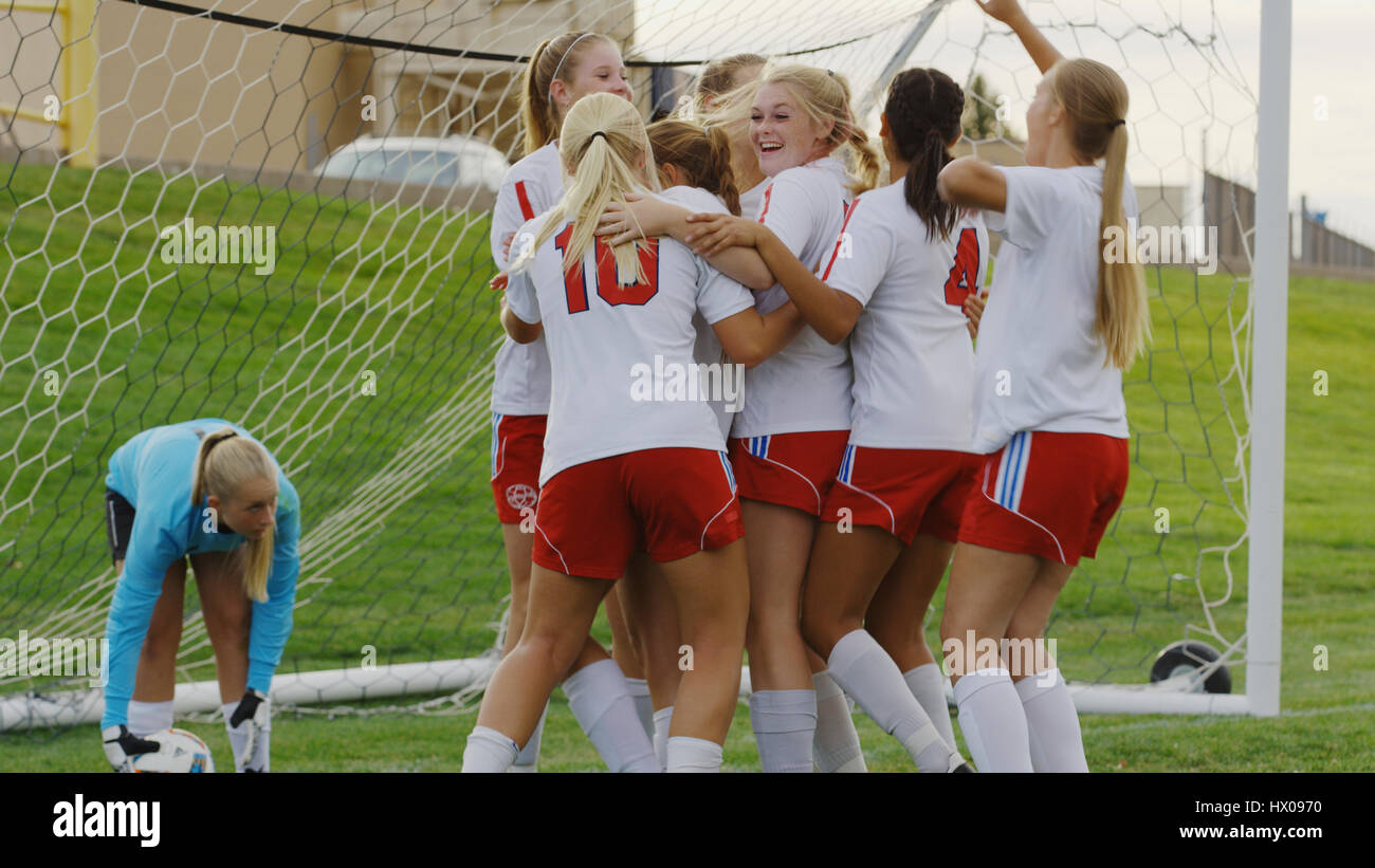 Proud athlete with soccer teammate cheering after game victory in goal ...